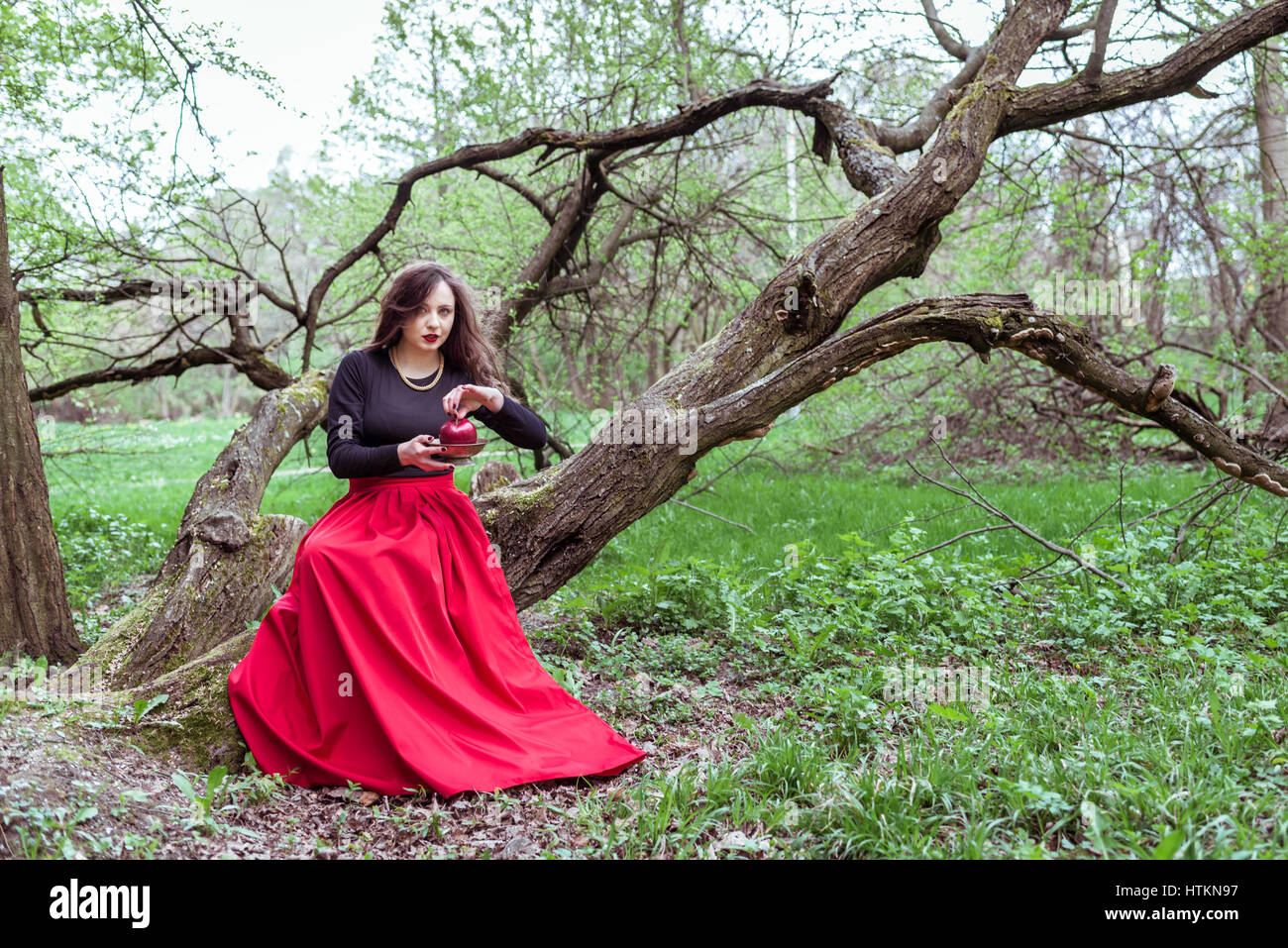 girl sitting on a tree trunk Stock Photo - Alamy