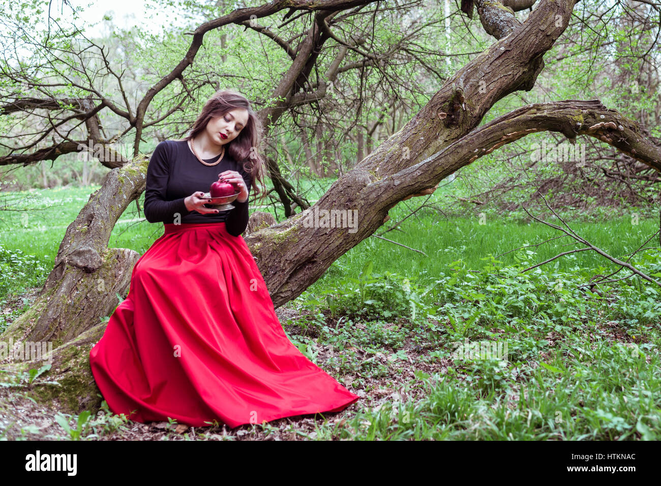 girl sitting on a tree trunk Stock Photo - Alamy