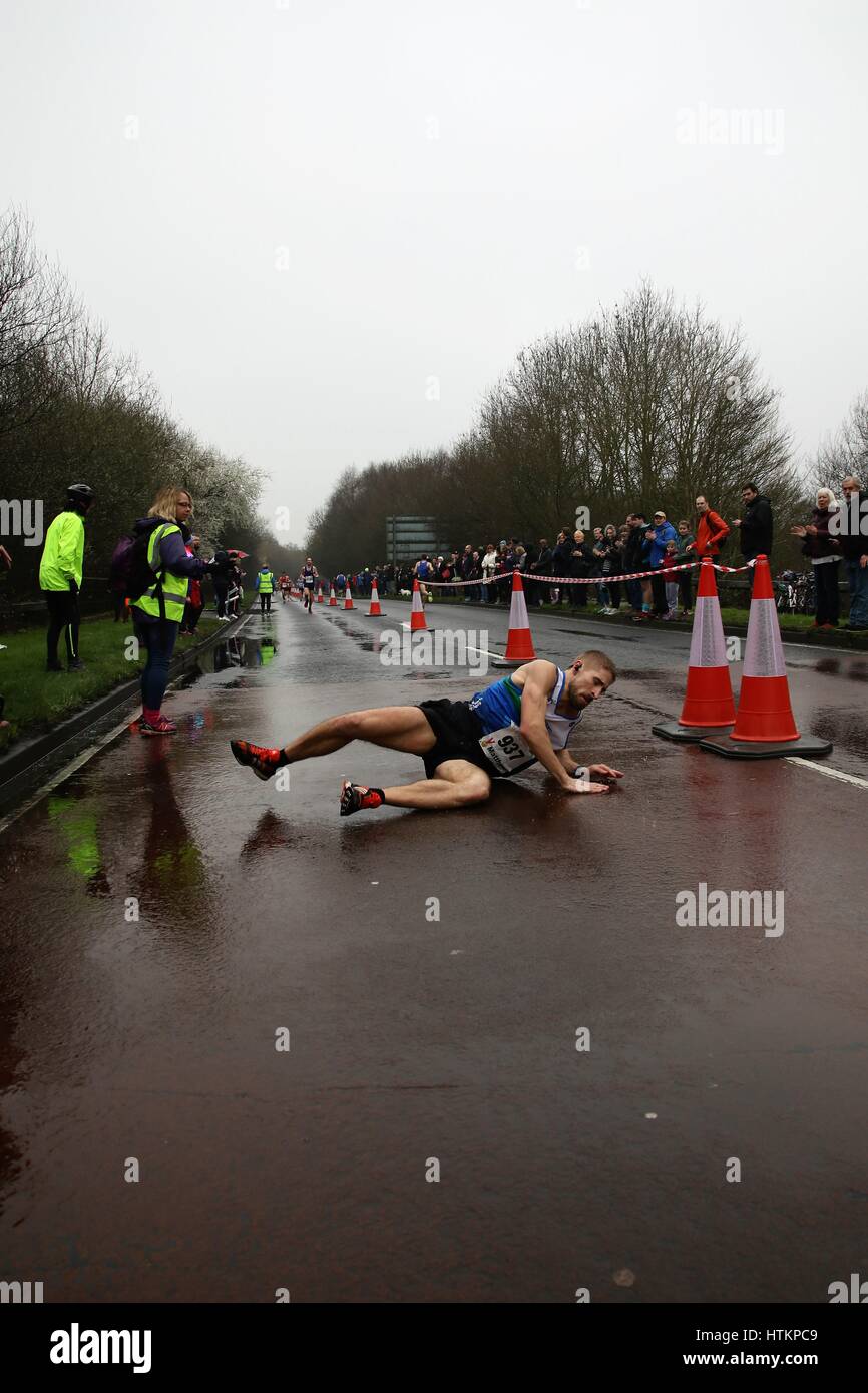A runner falls and slides along the ground as he fails to take a ...