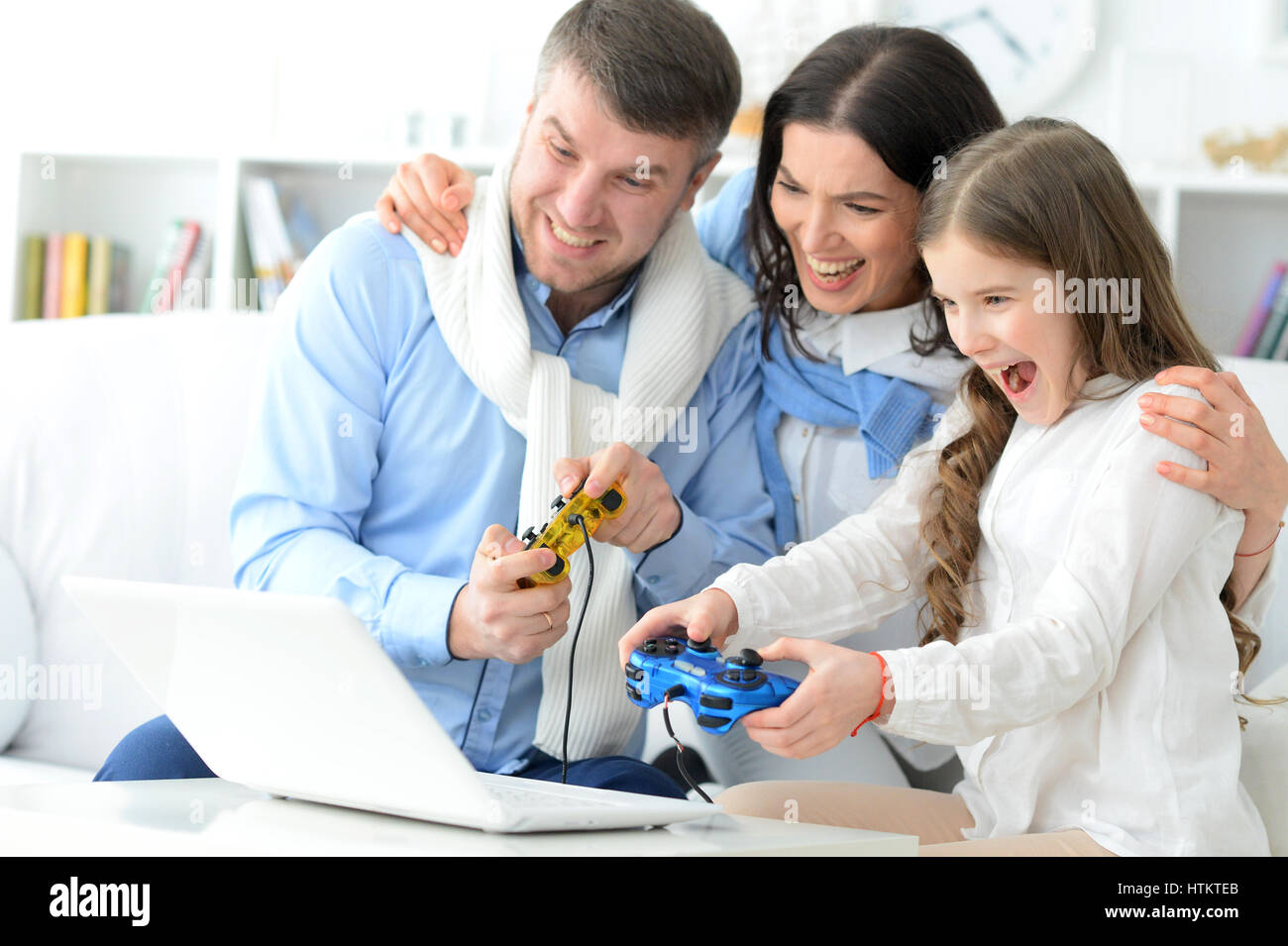 Family with daughter playing a computer game Stock Photo - Alamy