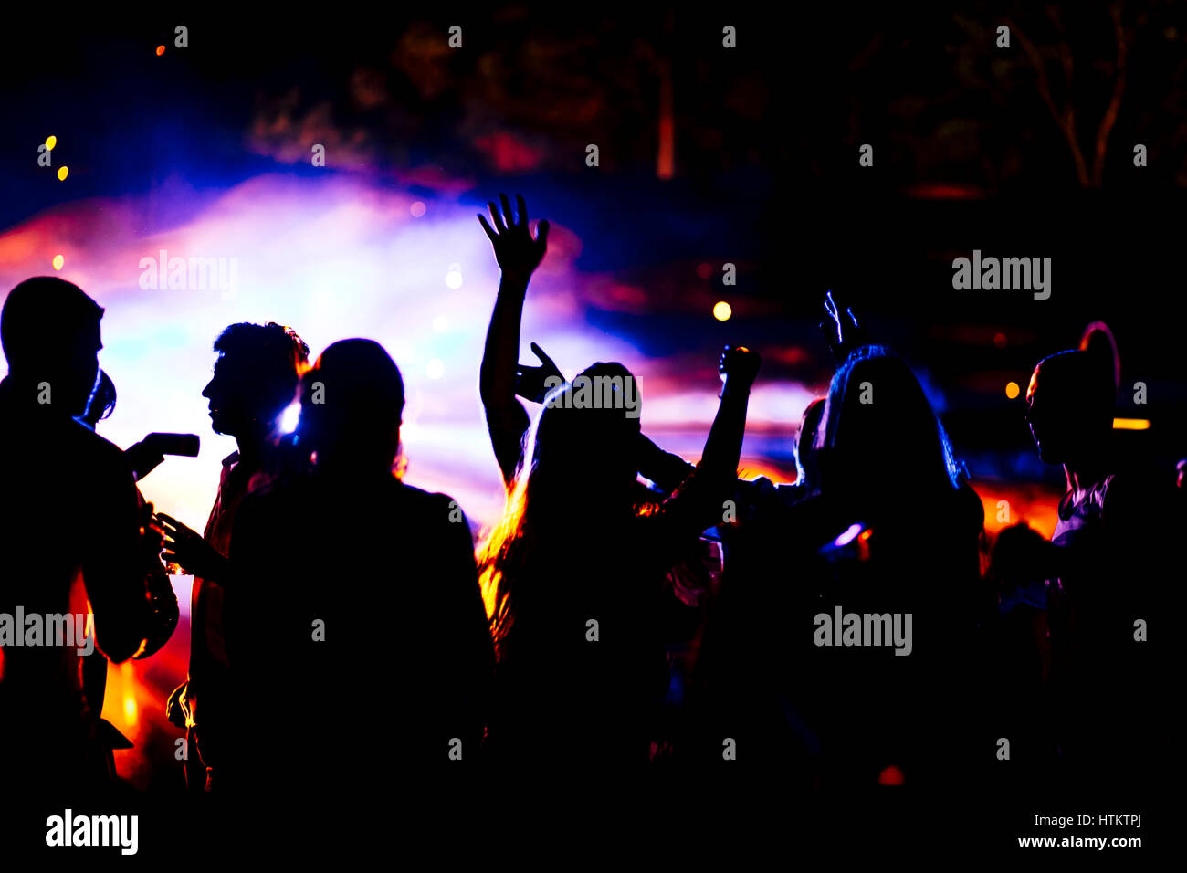 Large group of people on a dance floor. There is a very vivd colorful ...