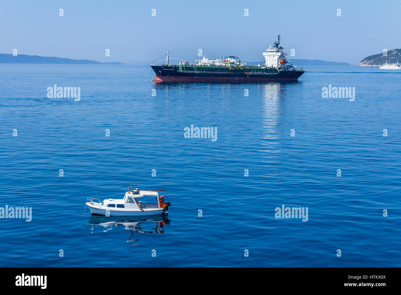 Split, Croatia - May 07, 2016: cargo ship passing a small boat Stock ...