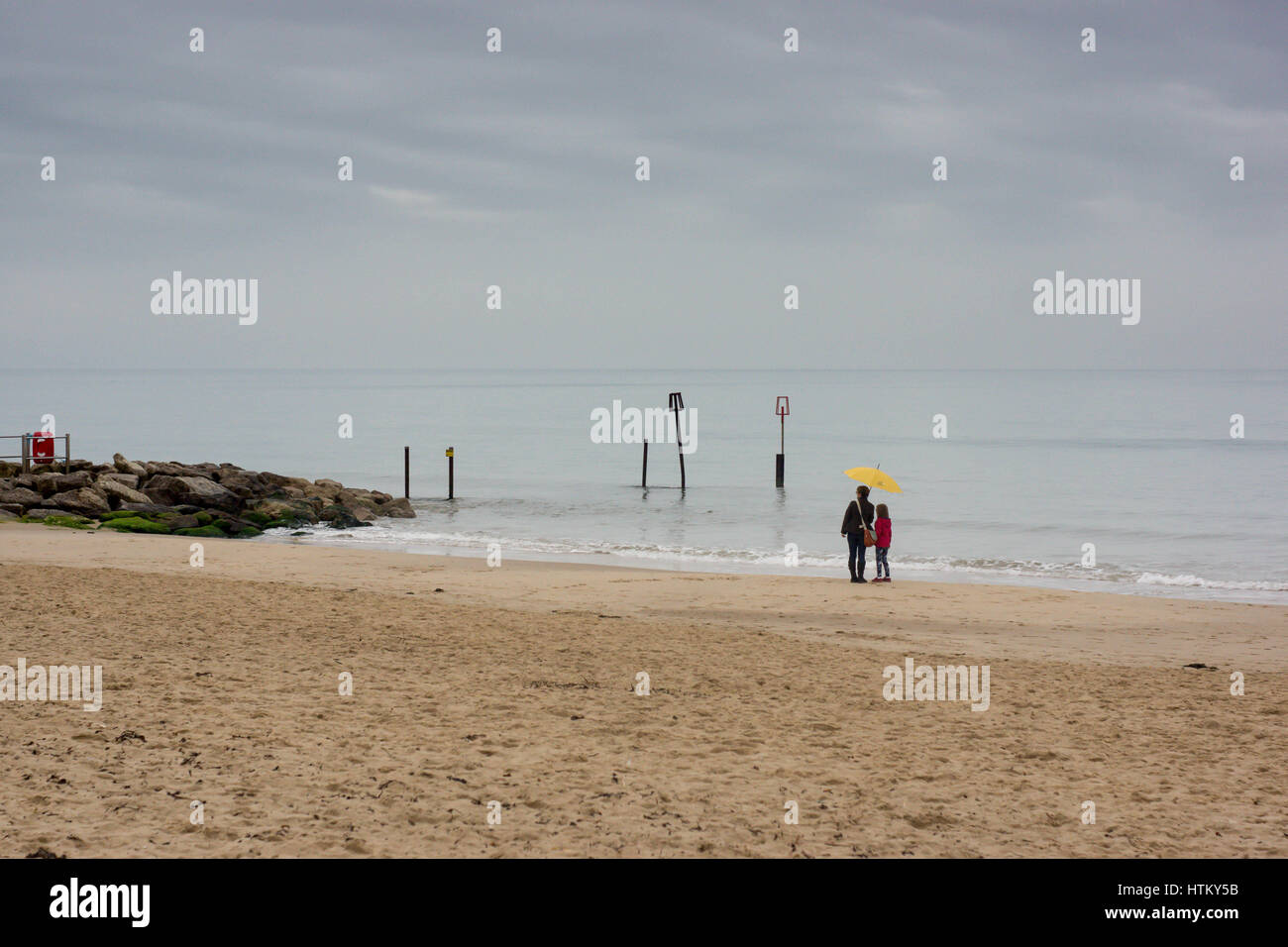Adult and child on the beach in the rain Stock Photo - Alamy