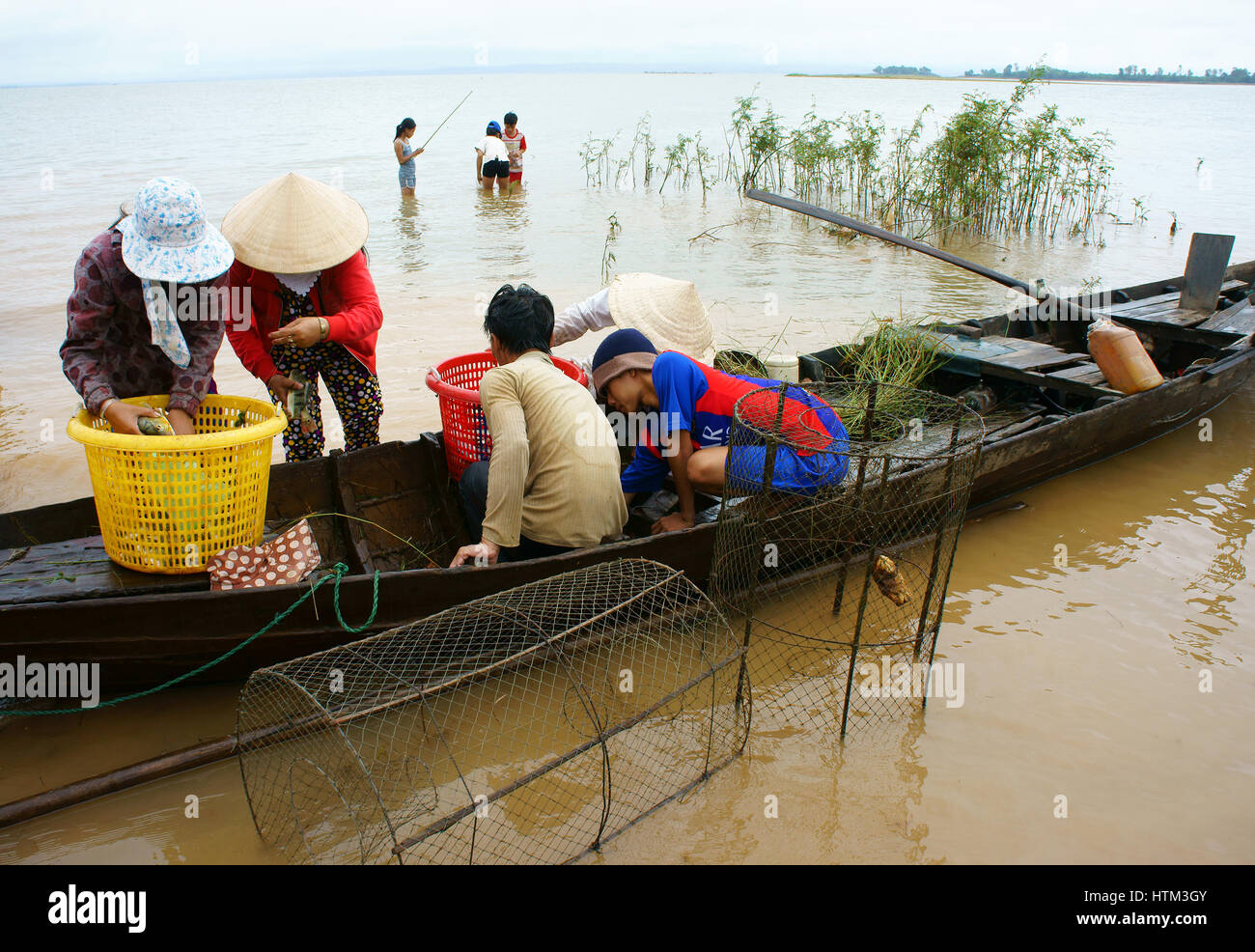 Dong Nai, Viet Nam, Asian fisherman fishing on Tri An lake, a branch of ...