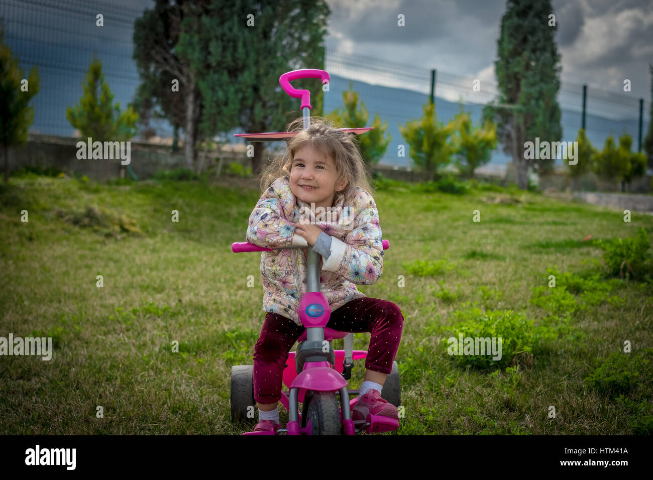 kid girl riding three wheels bike Stock Photo - Alamy