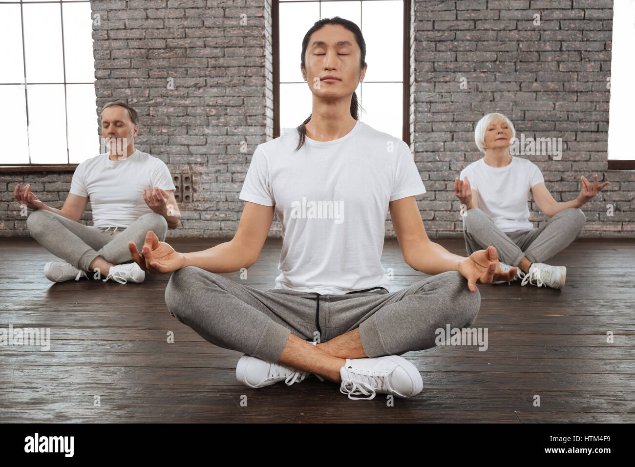 Relaxed group of healthy people while meditating Stock Photo - Alamy