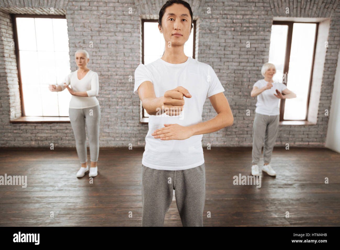 Two female standing behind Asian instructor Stock Photo - Alamy