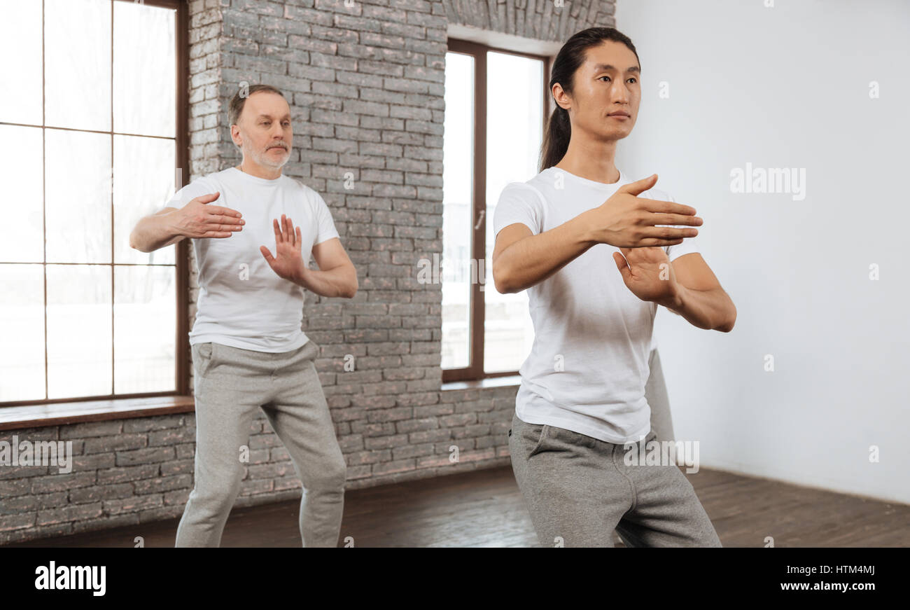 Two male persons doing yoga poses Stock Photo - Alamy
