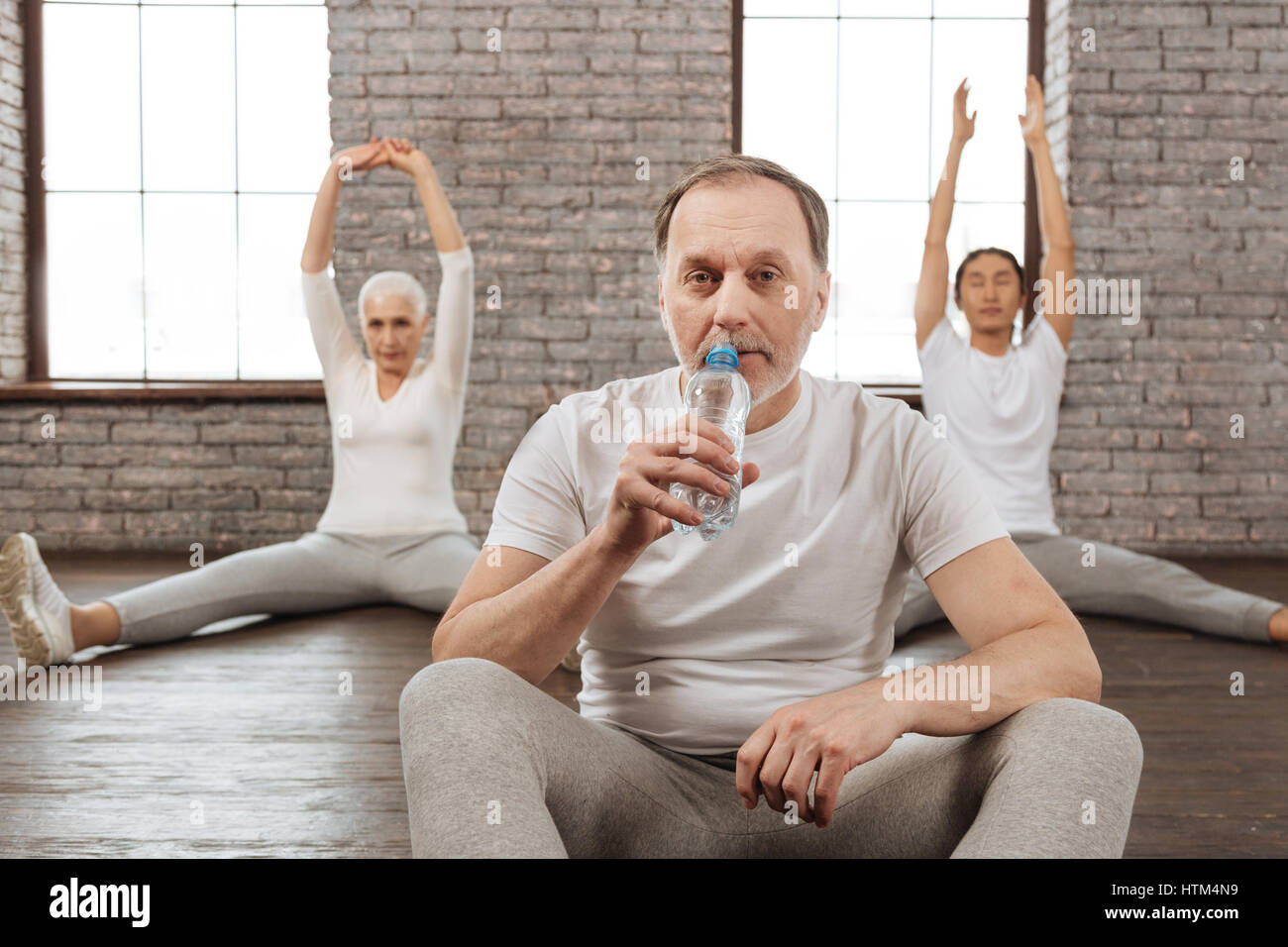 Handsome man holding little bottle of water Stock Photo - Alamy