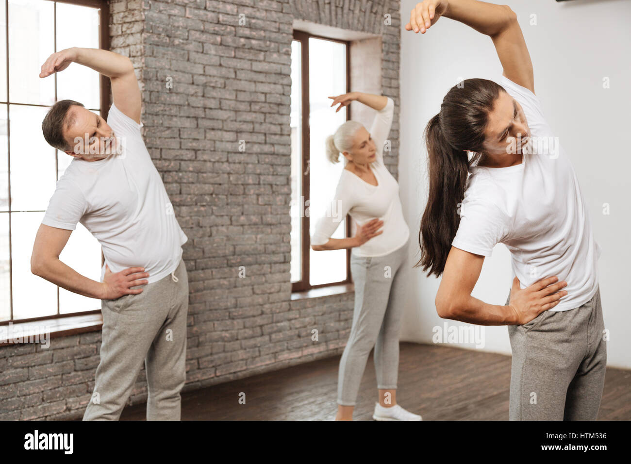 Three active people standing in semi position Stock Photo - Alamy