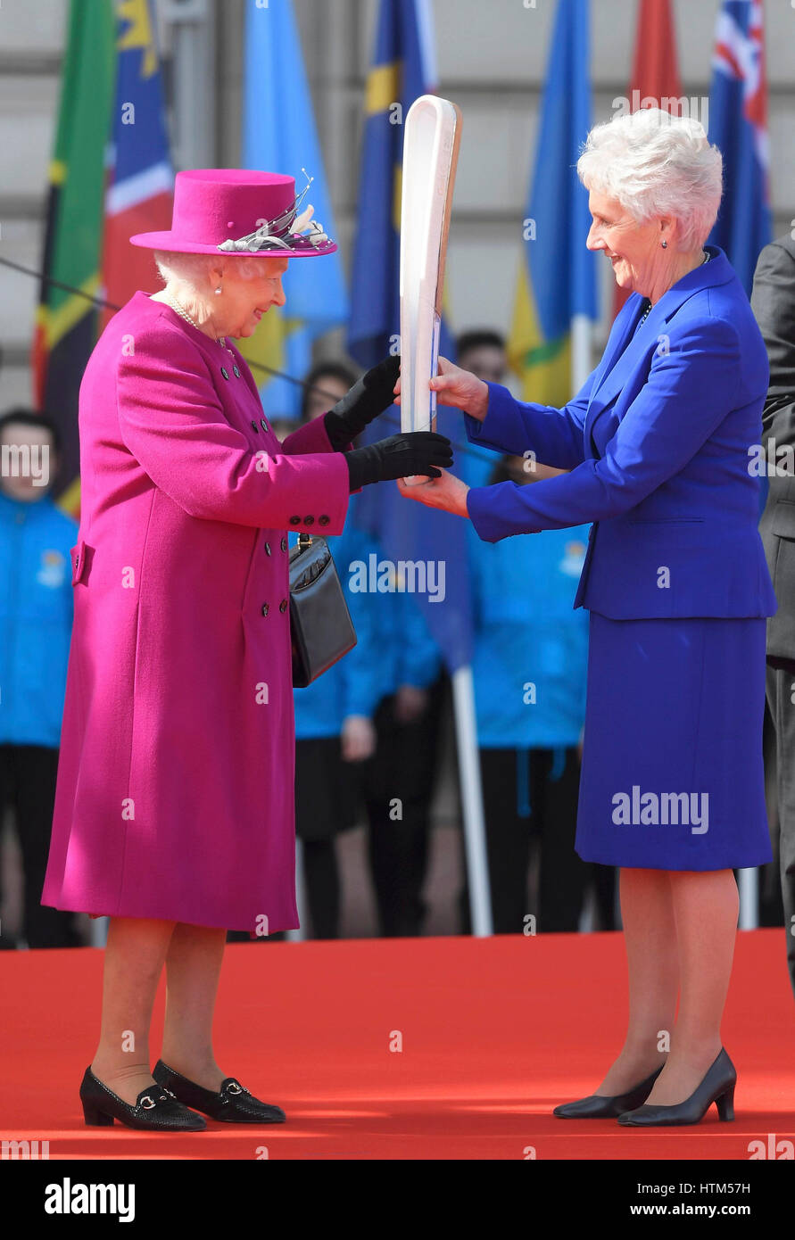 Queen Elizabeth II receives the baton from Louise Martin of the ...