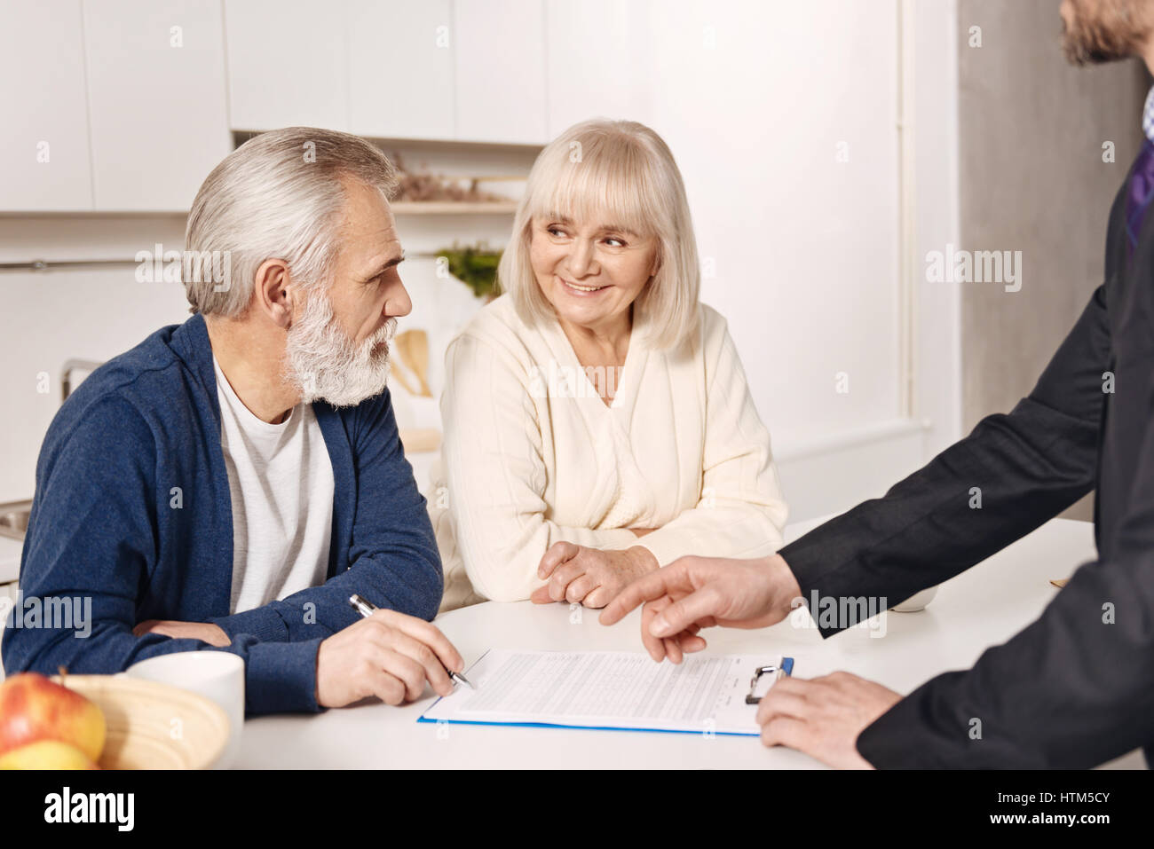 Delighted elderly couple signing agreement at home Stock Photo - Alamy
