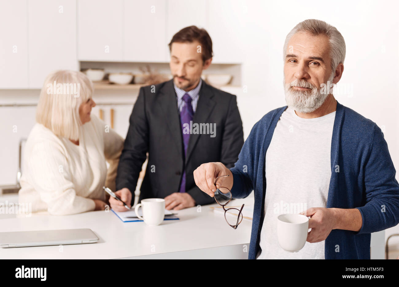 Aged man drinking tea while his wife signing the contact Stock Photo ...