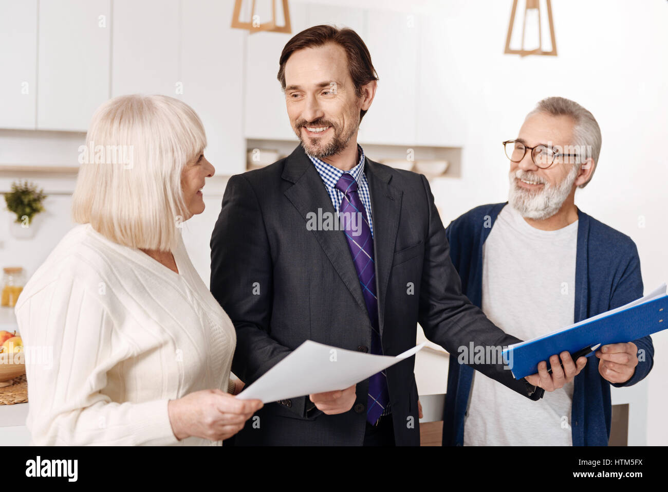 Competent legal advisor presenting contract for aged couple of clients ...