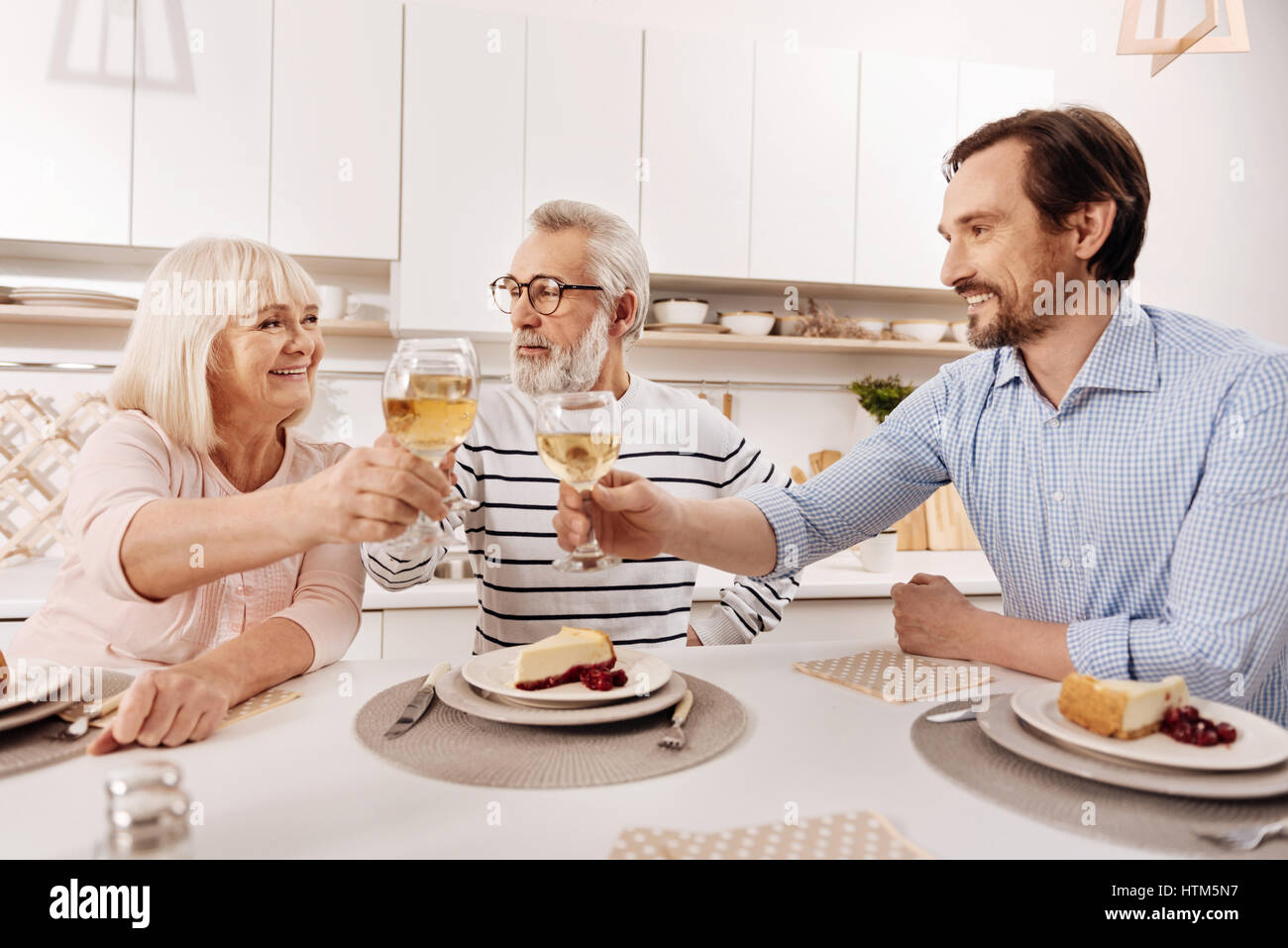 Cheerful man greeting his parents with holiday at home Stock Photo - Alamy