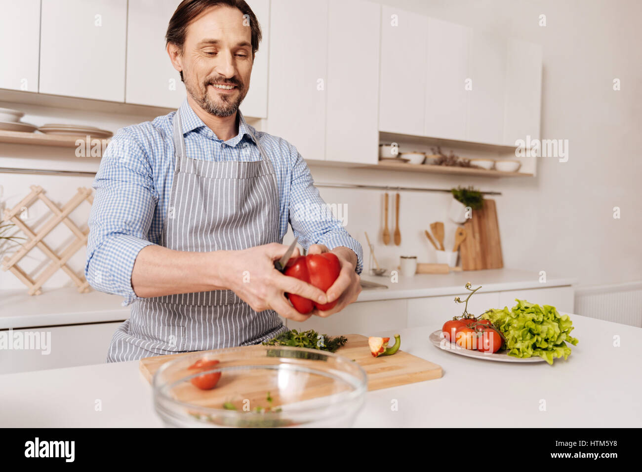 Emotional positive cook preparing healthy dinner in the kitchen Stock ...