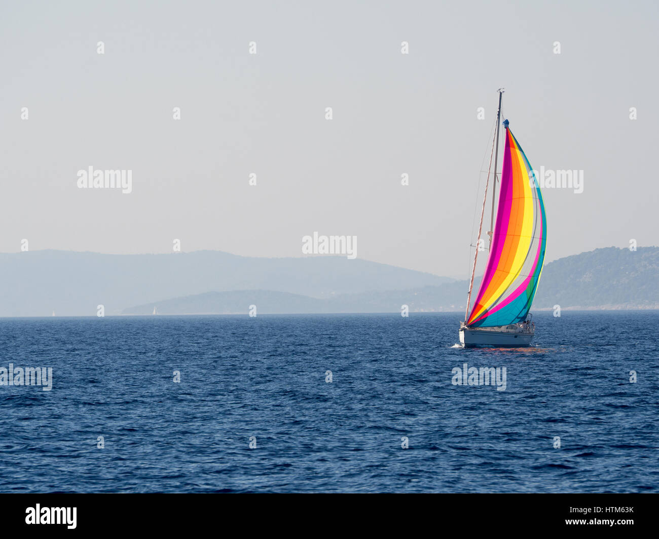 a yacht sailboat boat with multicoloured multicolored sail sails ...