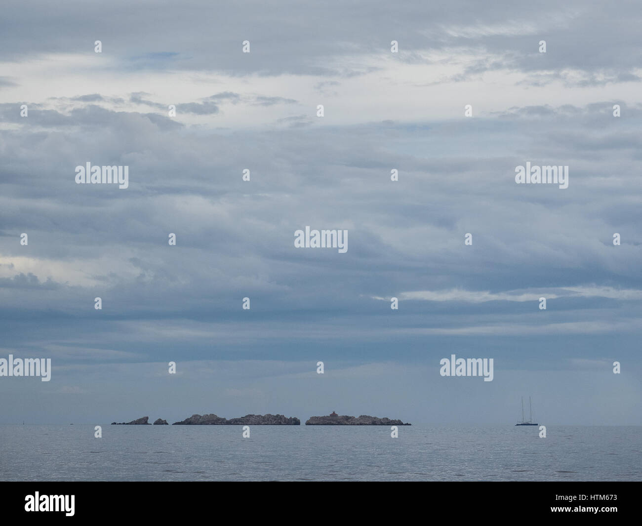 String line of islands and a yacht with two masts on the horizon under ...