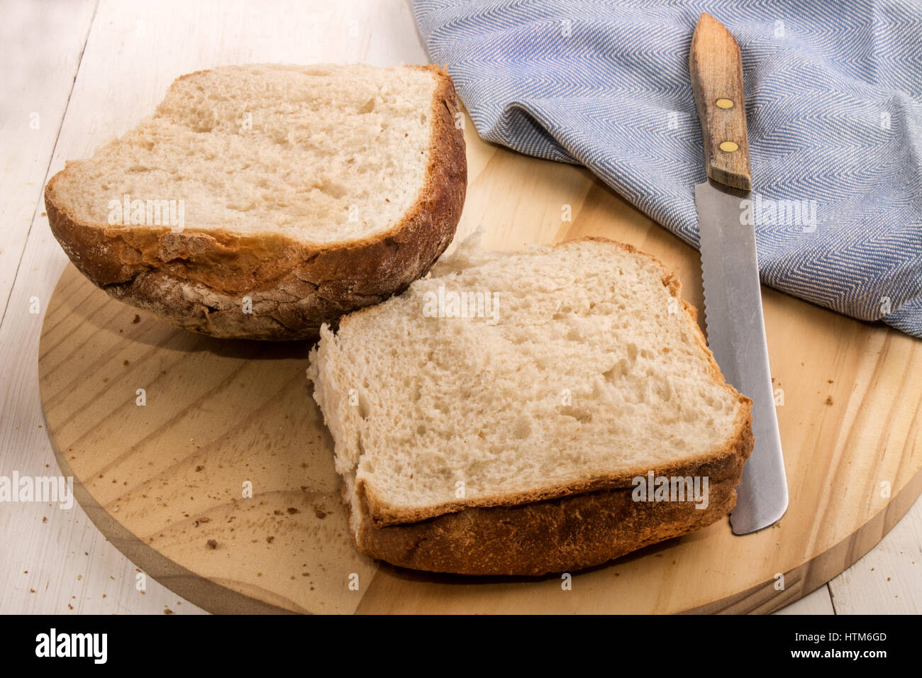 sliced northern irish breakfast bap on a round wooden board with bread ...