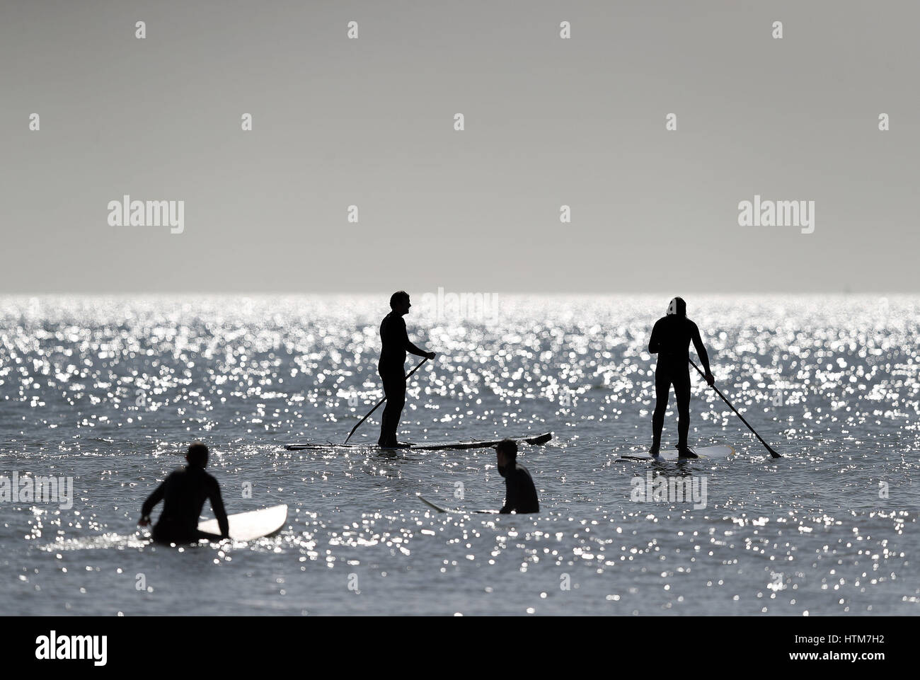 Paddle borders and surfers wait for a wave off of Boscombe beach in ...