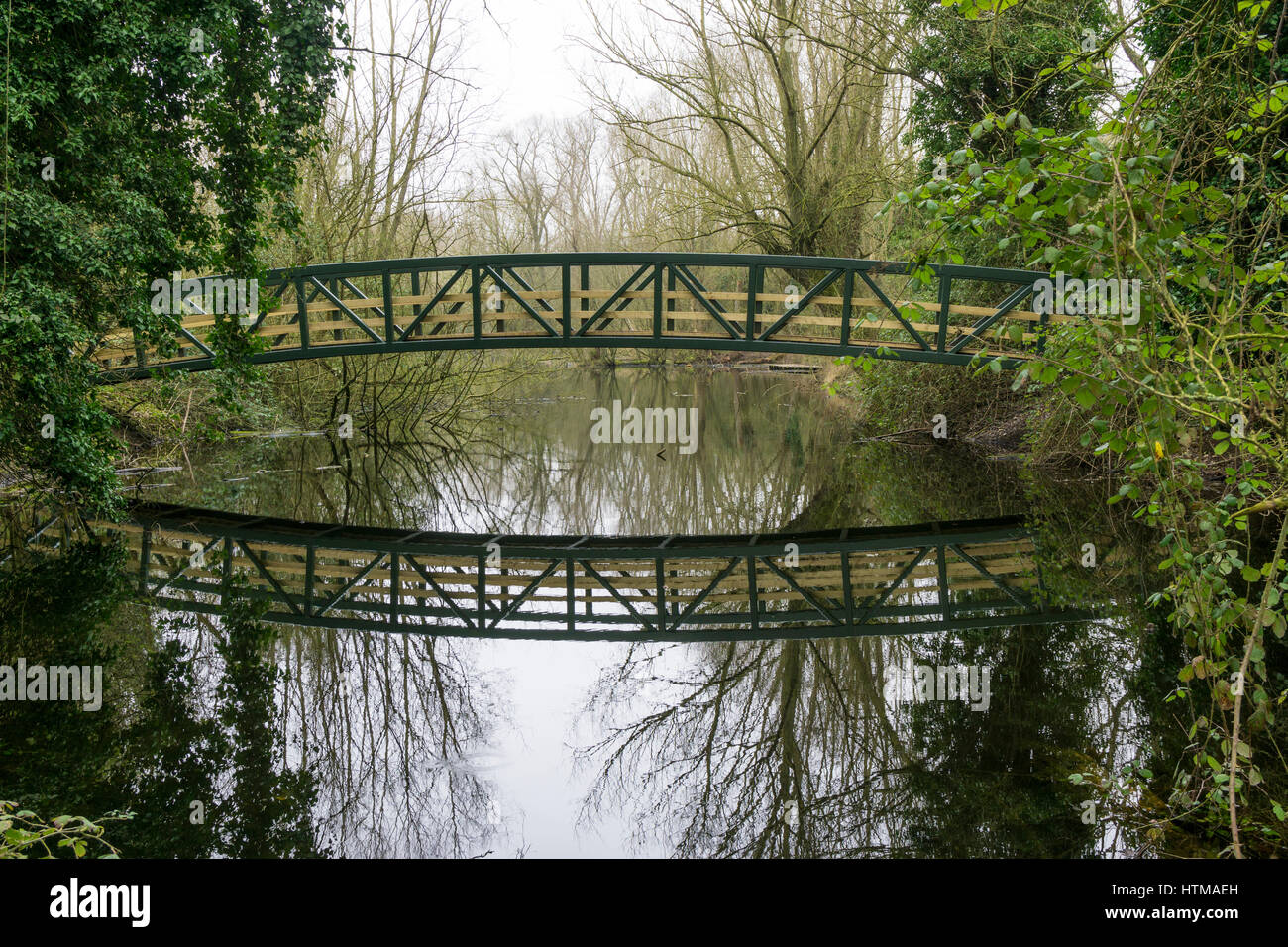 Footbridge and reflection in water Stock Photo - Alamy