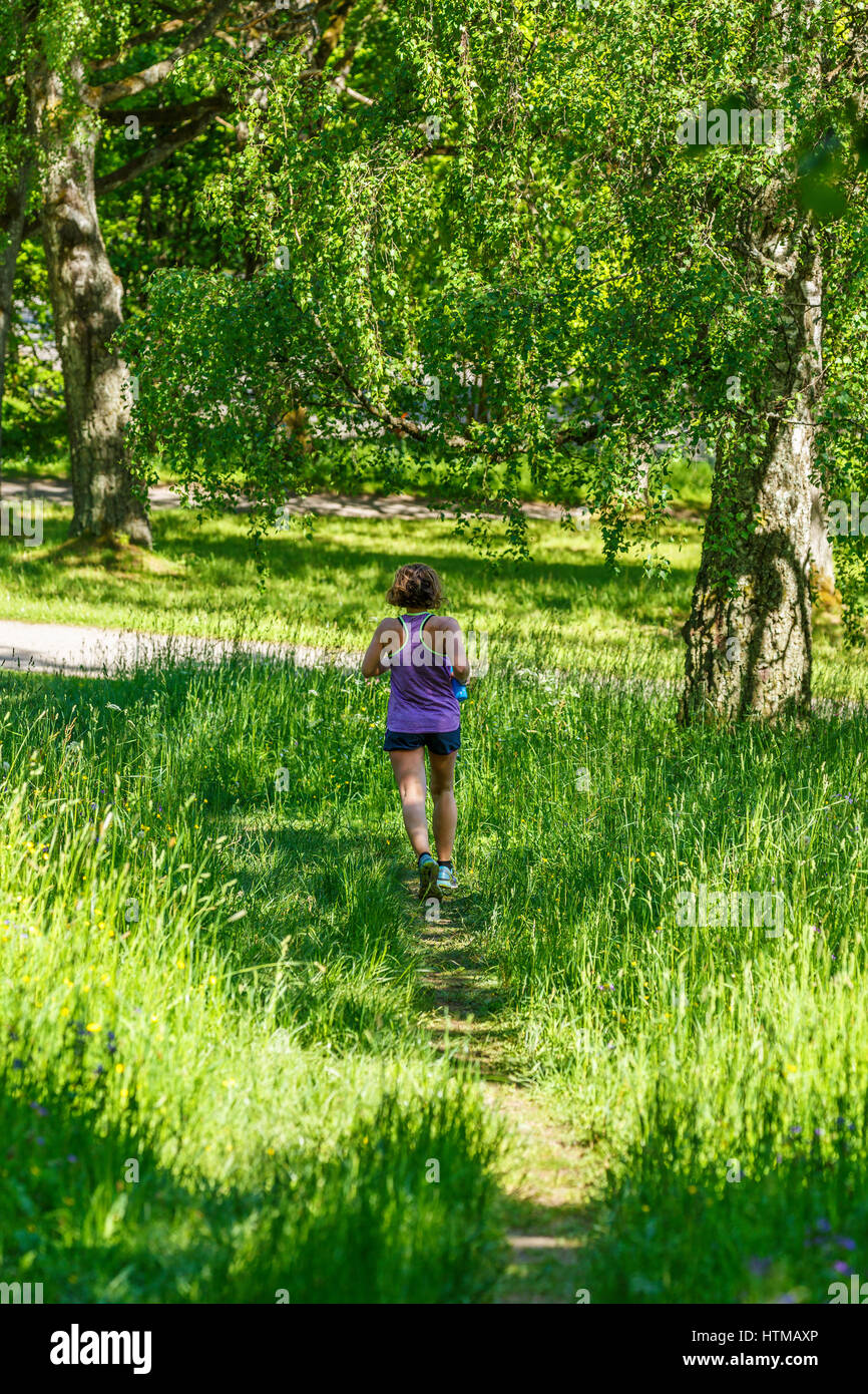 Woman running on a path in a park Stock Photo - Alamy