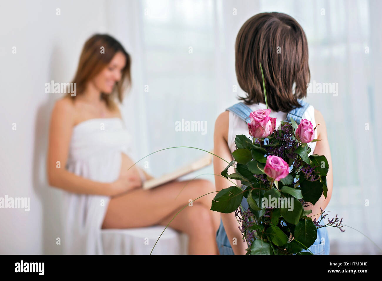 Sweet little preschool child, boy, giving flowers to his pregnant mom ...
