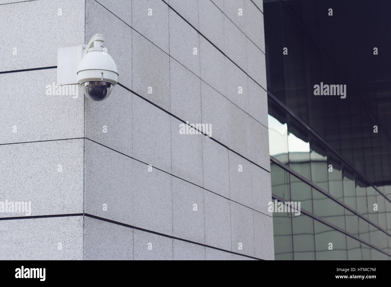 horizontal front view of white surveillance camera on business building ...