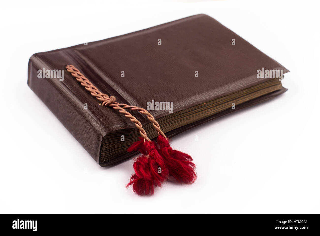 side view of vintage photo brown album cover with red lace bindings ...