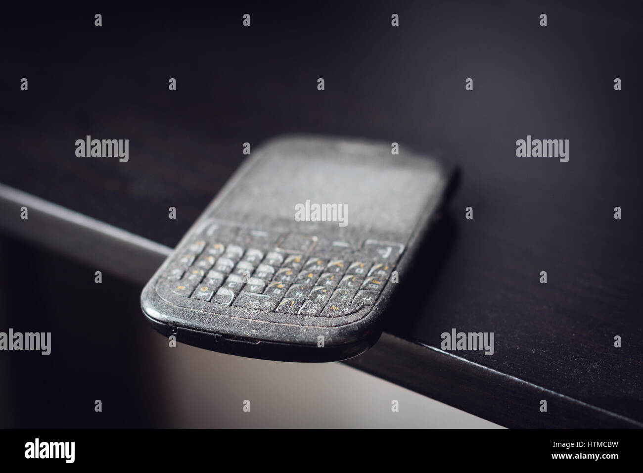 side view close up of old black smartphone mobile with qwerty keyboard ...