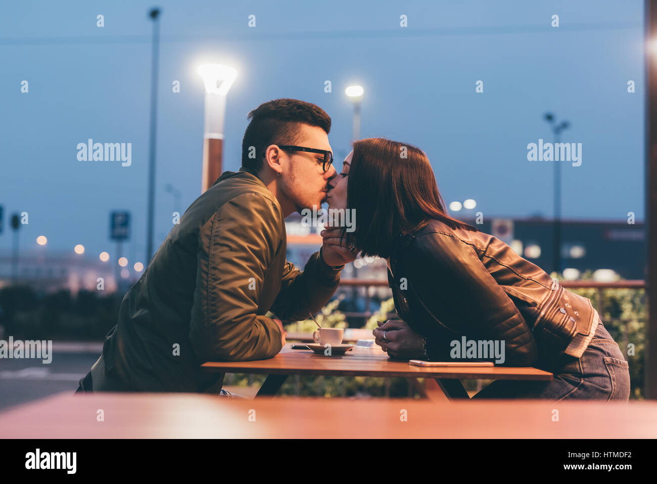 Young beautiful couple sitting outdoor in the night kissing - kiss ...