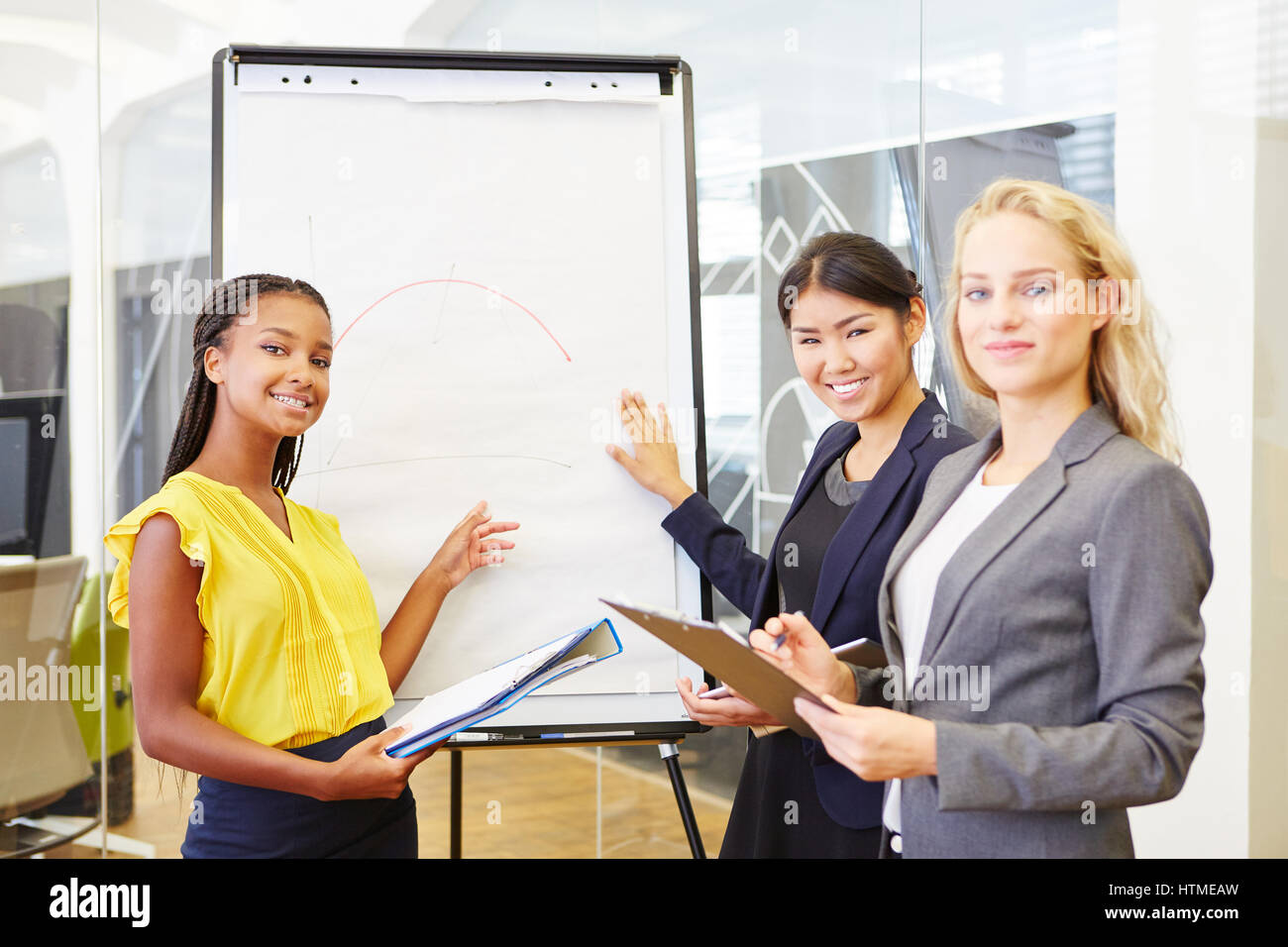 Interracial business team presenting flipchart in start-up meeting ...