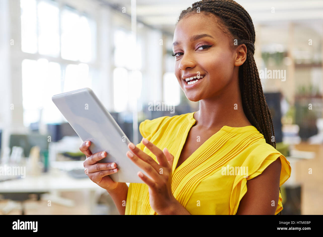 African student having fun with tablet computer using it for social ...