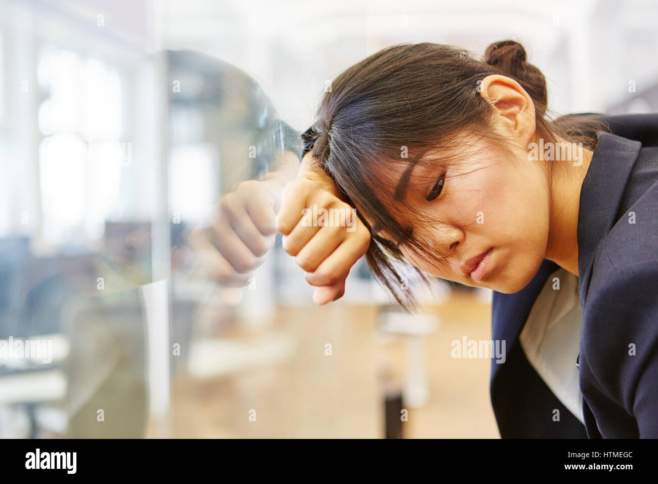 Asian businesswoman as a loser after exhaustion at work Stock Photo - Alamy