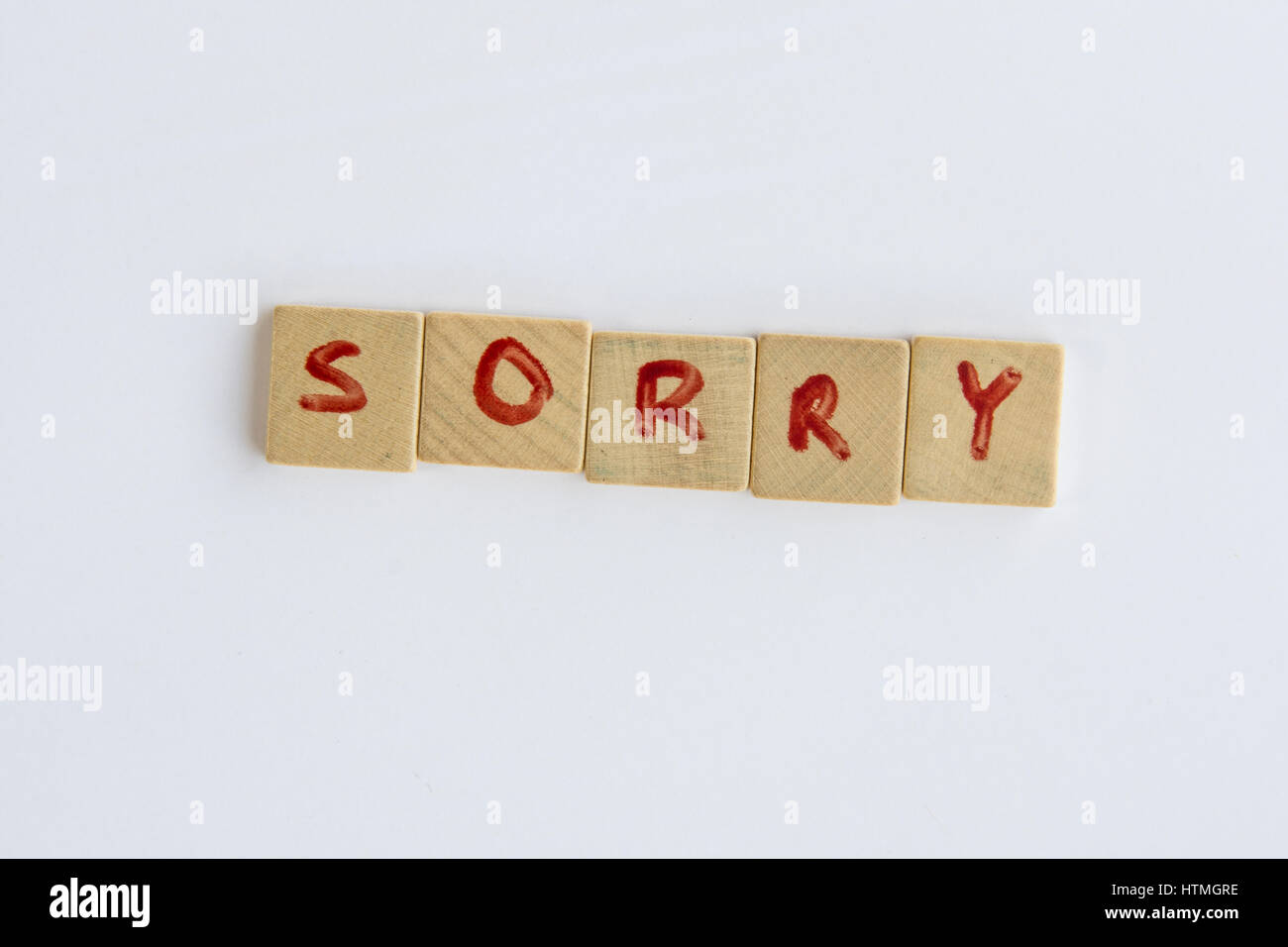 the word Sorry formed with letters written on squares of wood dowels ...