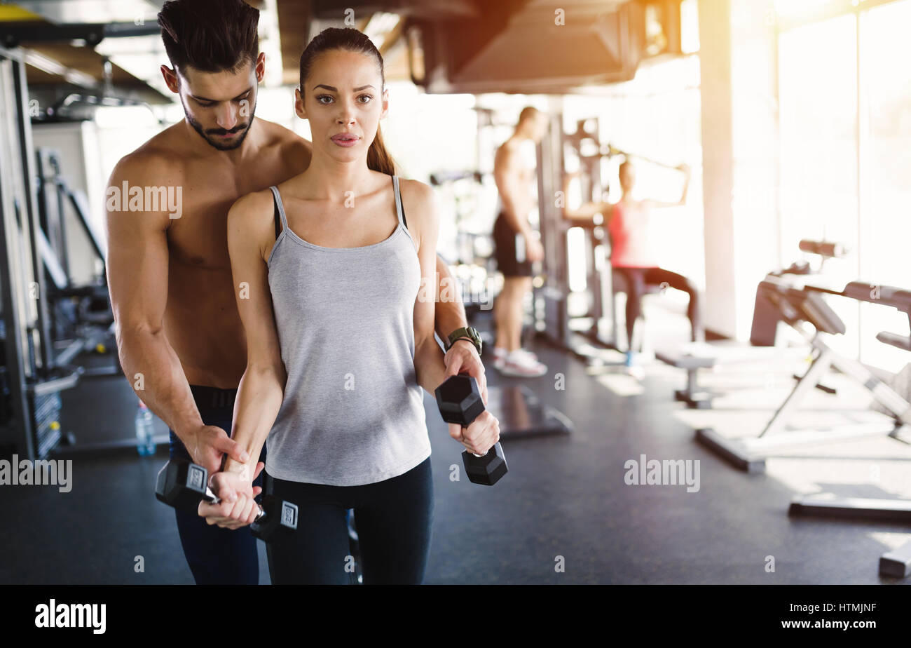 Personal trainer helping woman reach goals in gym Stock Photo - Alamy