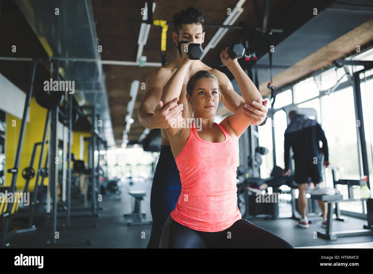 Personal trainer helping woman reach goals in gym Stock Photo - Alamy