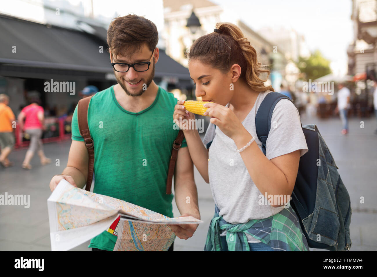 Young happy tourists holding map sightseeing in city Stock Photo - Alamy