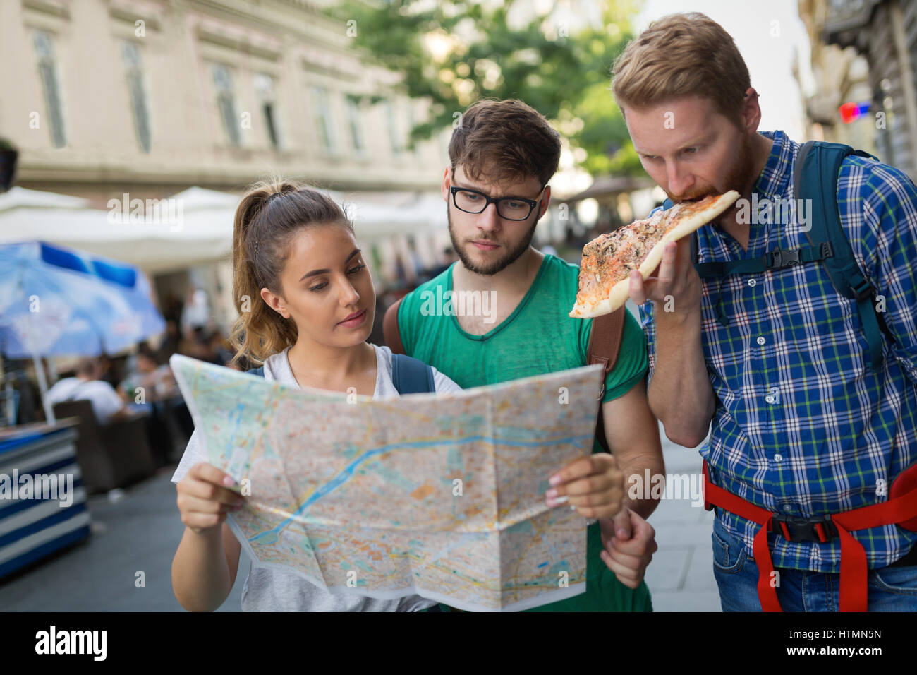 Young happy tourists holding map sightseeing in city Stock Photo - Alamy