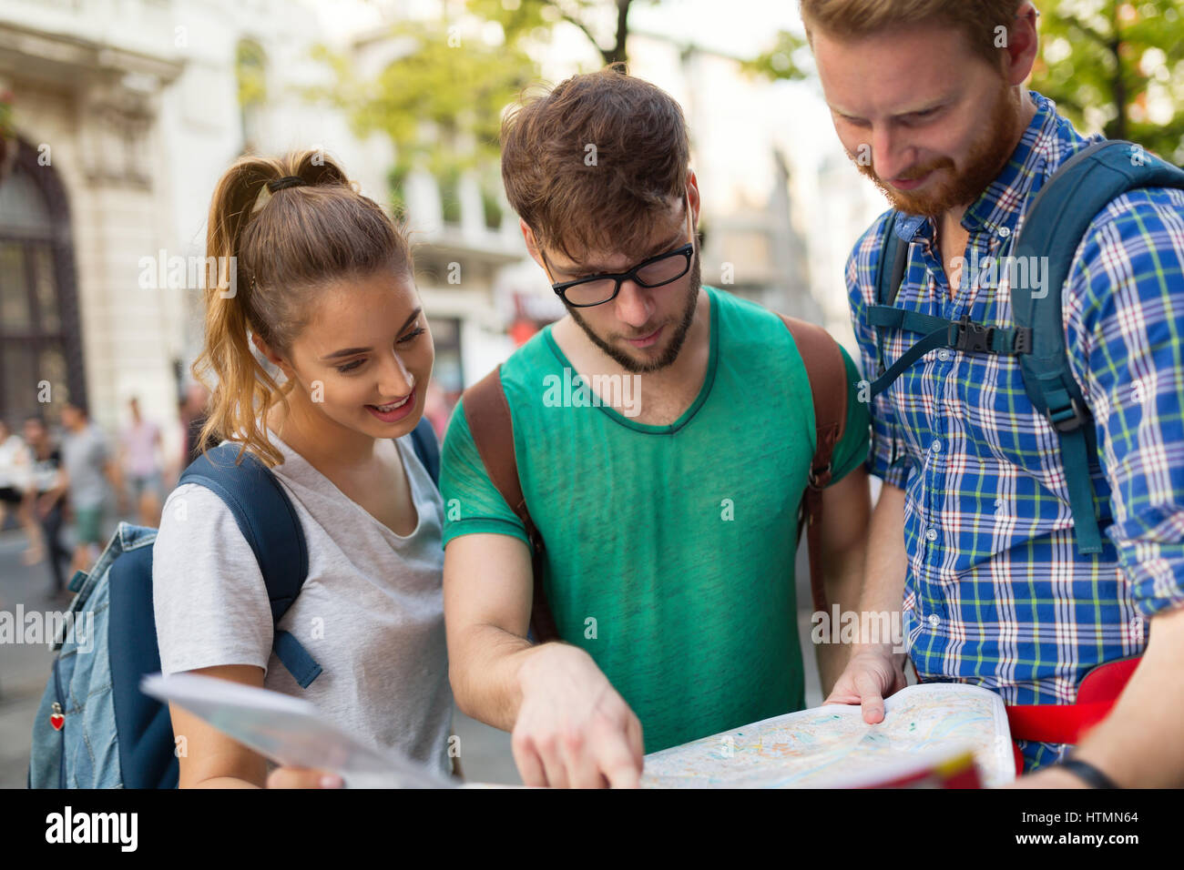 Young happy tourists holding map sightseeing in city Stock Photo - Alamy