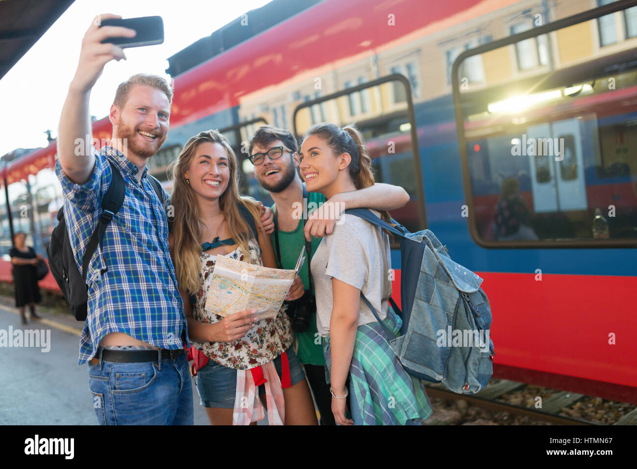 Young group of travelling tourists at train station Stock Photo - Alamy