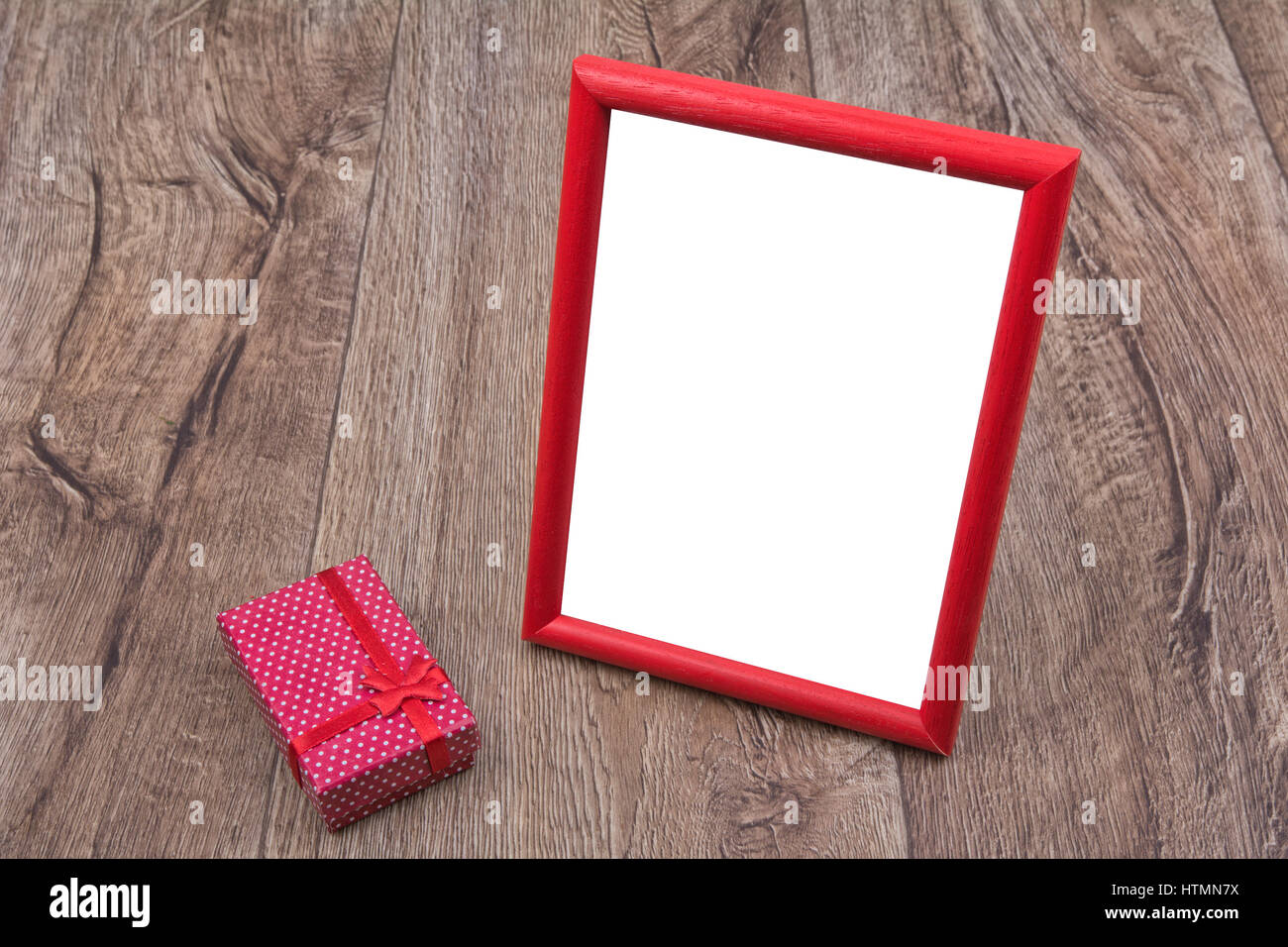 Red picture frame with a gift on a wooden background Stock Photo - Alamy