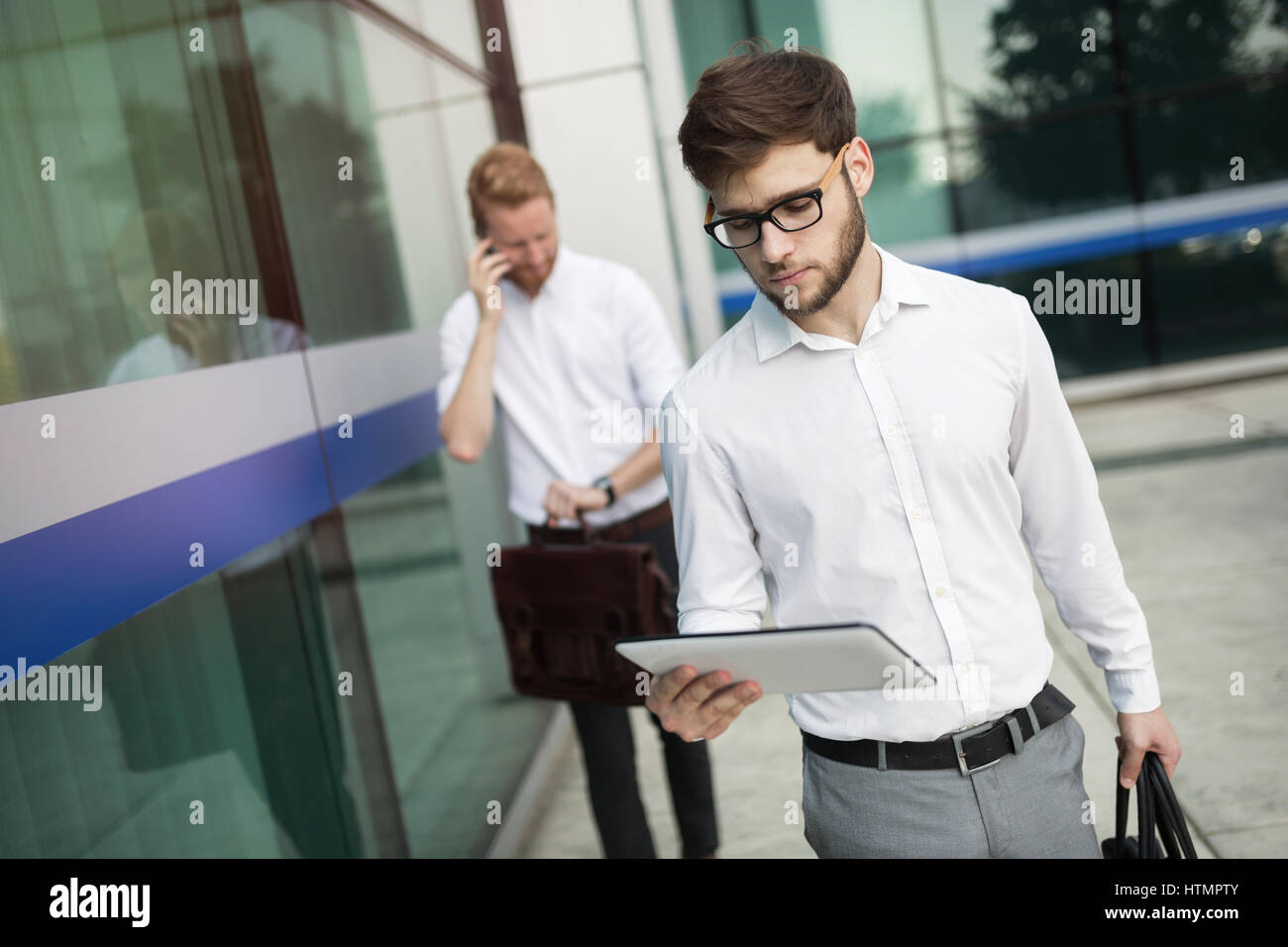 Business people walking outdoors and using phones tablets Stock Photo ...