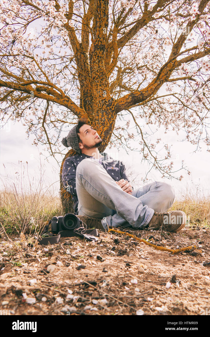 Young hipster man taking shots near a blossom tree in spring Stock ...