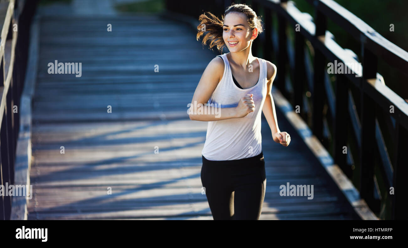 Sporty female jogger running and training outside in nature Stock Photo ...