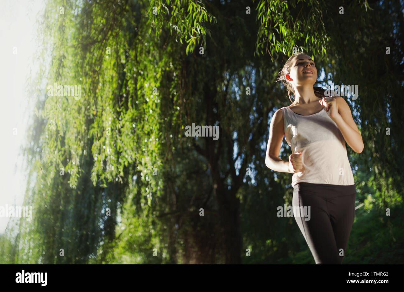 Beautiful female jogger running outside in nature Stock Photo - Alamy