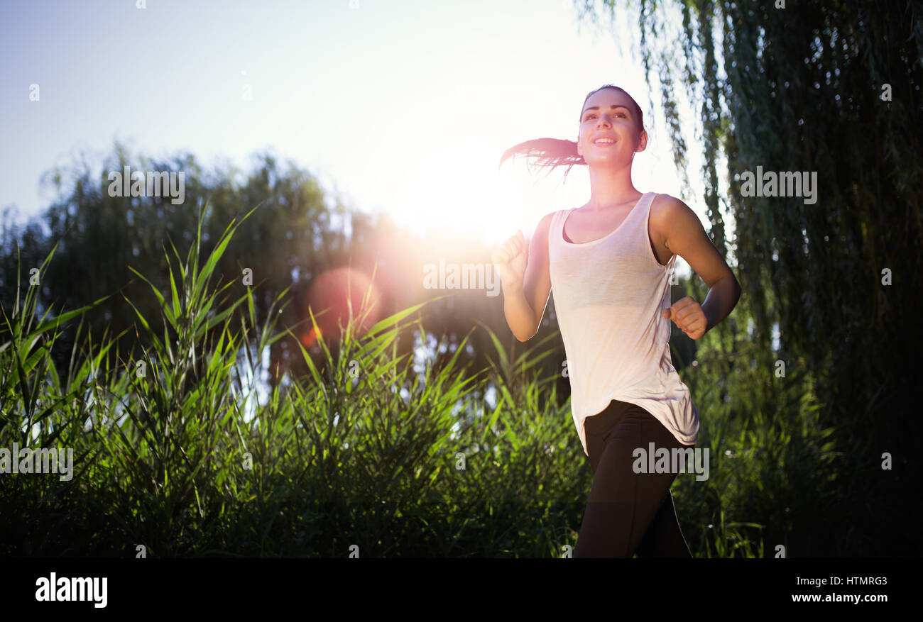 Beautiful female jogger running outside in nature Stock Photo - Alamy