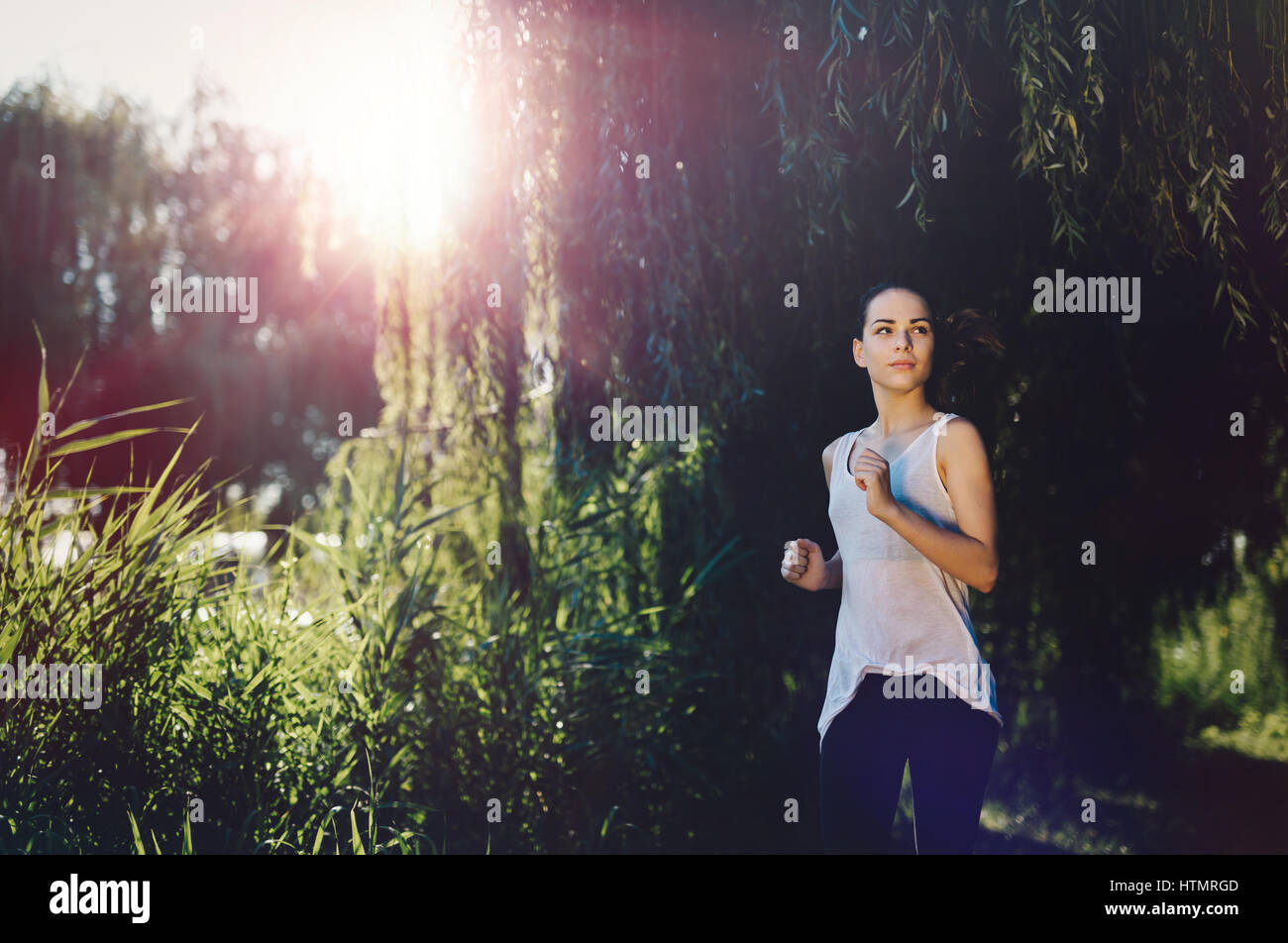 Beautiful female jogger running outside in nature Stock Photo - Alamy
