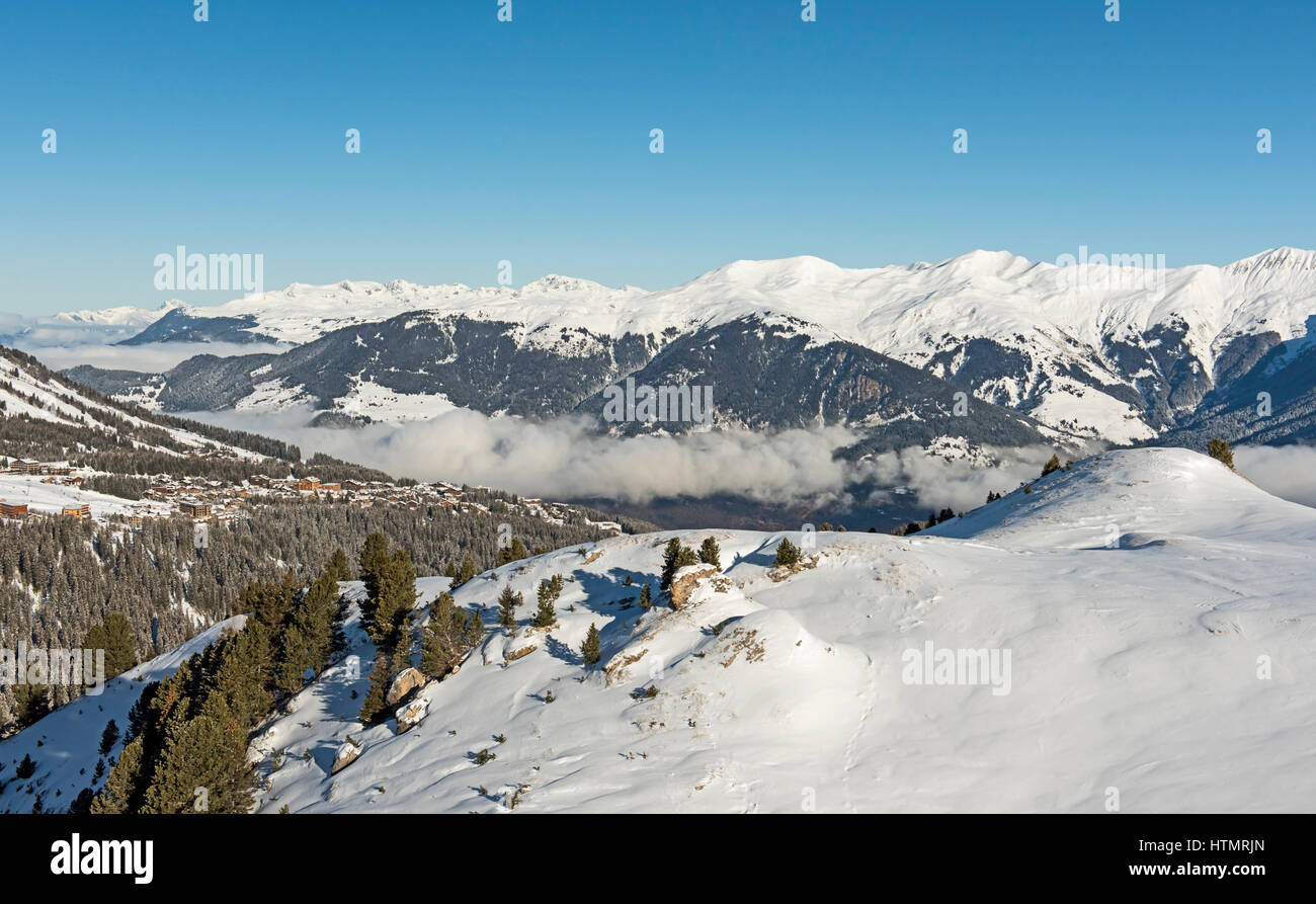 Panoramic view down snow covered valley in alpine mountain range with ...