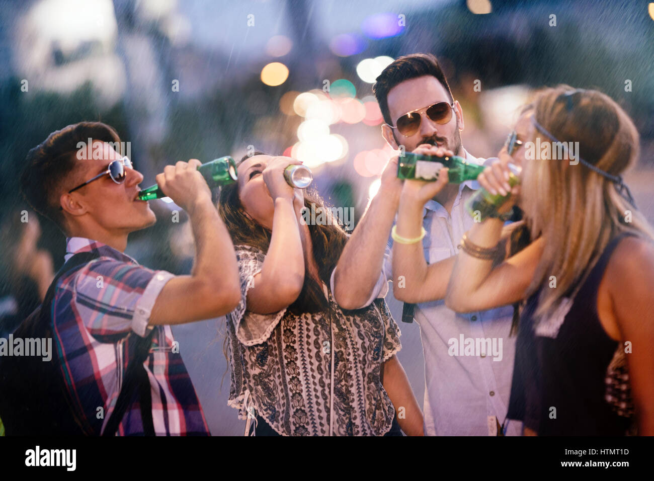 Happy friends drinking alcohol outdoors and partying before festival ...